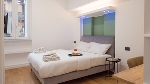 Um quarto moderno com uma cama, mesas de cabeceira e uma janela.
