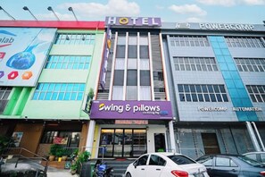 Um hotel com uma placa indicando 'Swing & Pillows' e 'PowerComp Automation' na fachada.