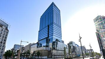 Um edifício moderno e imponente com fachada de vidro, cercado por outros edifícios comerciais.