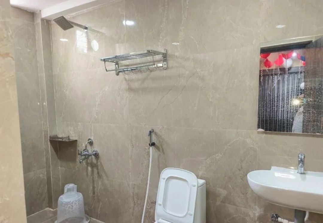 Um banheiro com chuveiro, vaso sanitário e pia.