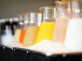 Uma fileira de balões de laboratório com líquidos de cores diferentes, provavelmente para experimentos científicos.