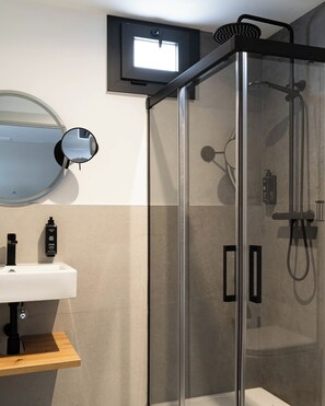 One-Bedroom Suite with balcony | Casa de banho | Um polibã, artigos de higiene ecológicos, um secador de cabelo 