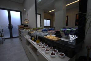Uma mesa de buffet com diversos alimentos e acompanhamentos.