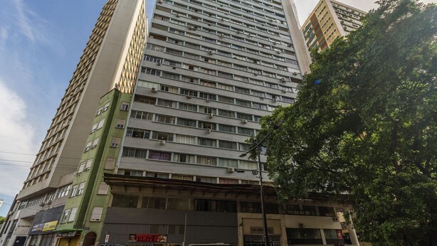 Edifício de vários andares com espaço comercial no térreo, incluindo um restaurante e uma loja.