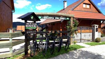 Um edifício de madeira com uma placa que diz "Brezova Poljana" e bicicletas estacionadas na frente.