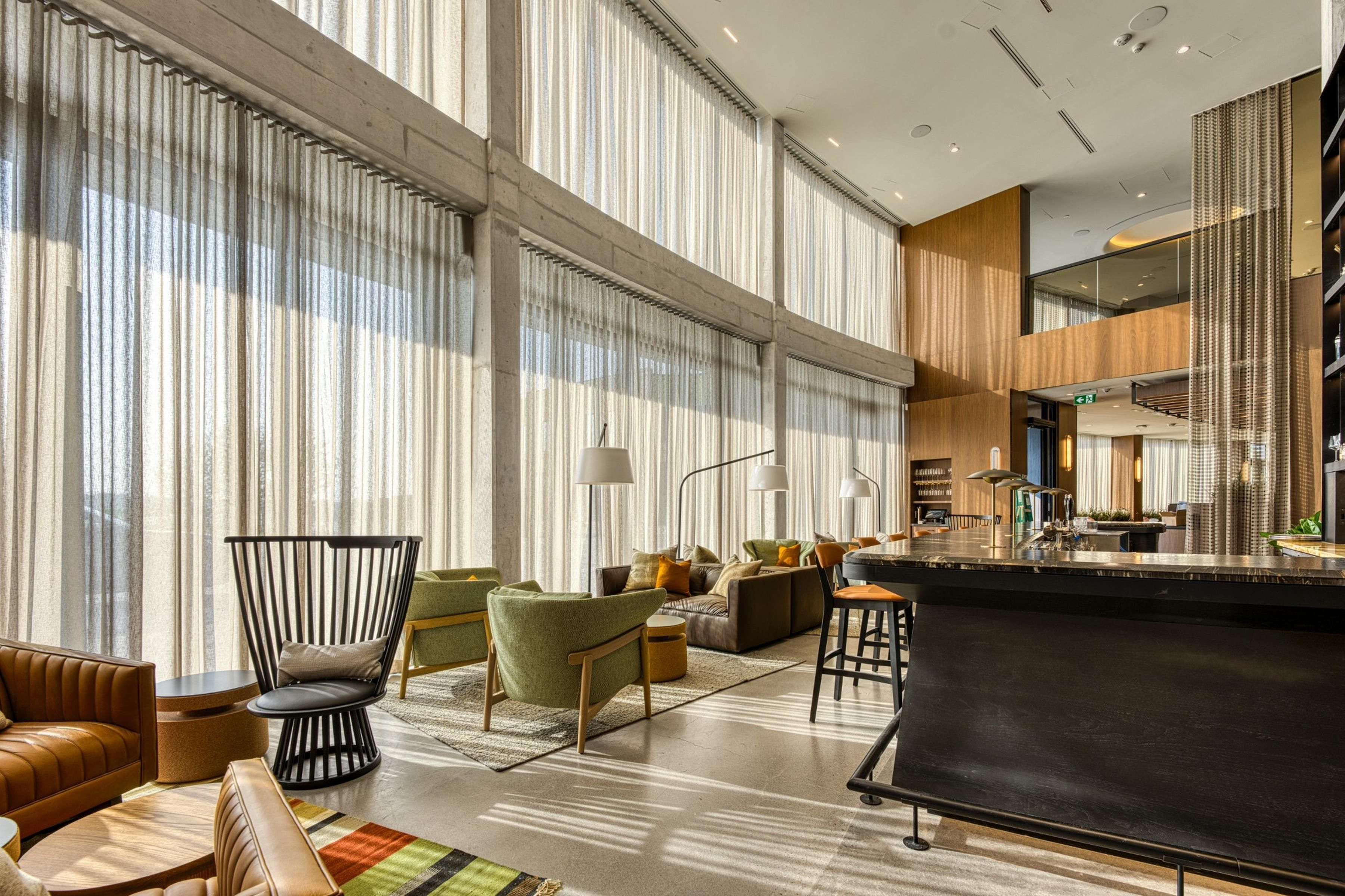 Decoração moderna com área de bar, assentos e grandes janelas.