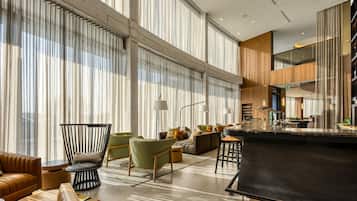 Decoração moderna com área de bar, assentos e grandes janelas.