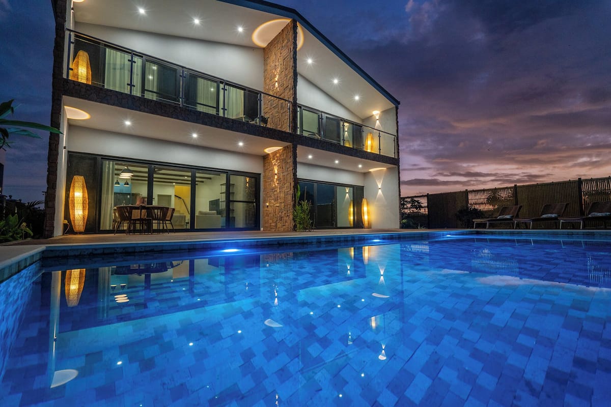 Um edifício moderno de dois andares com uma piscina em frente.