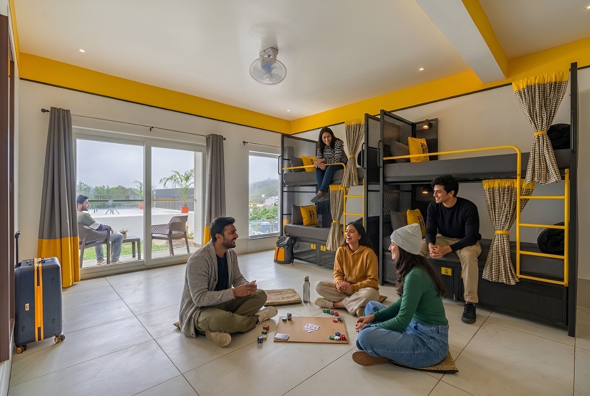 Quarto com beliches, área de estar e janela com vista.