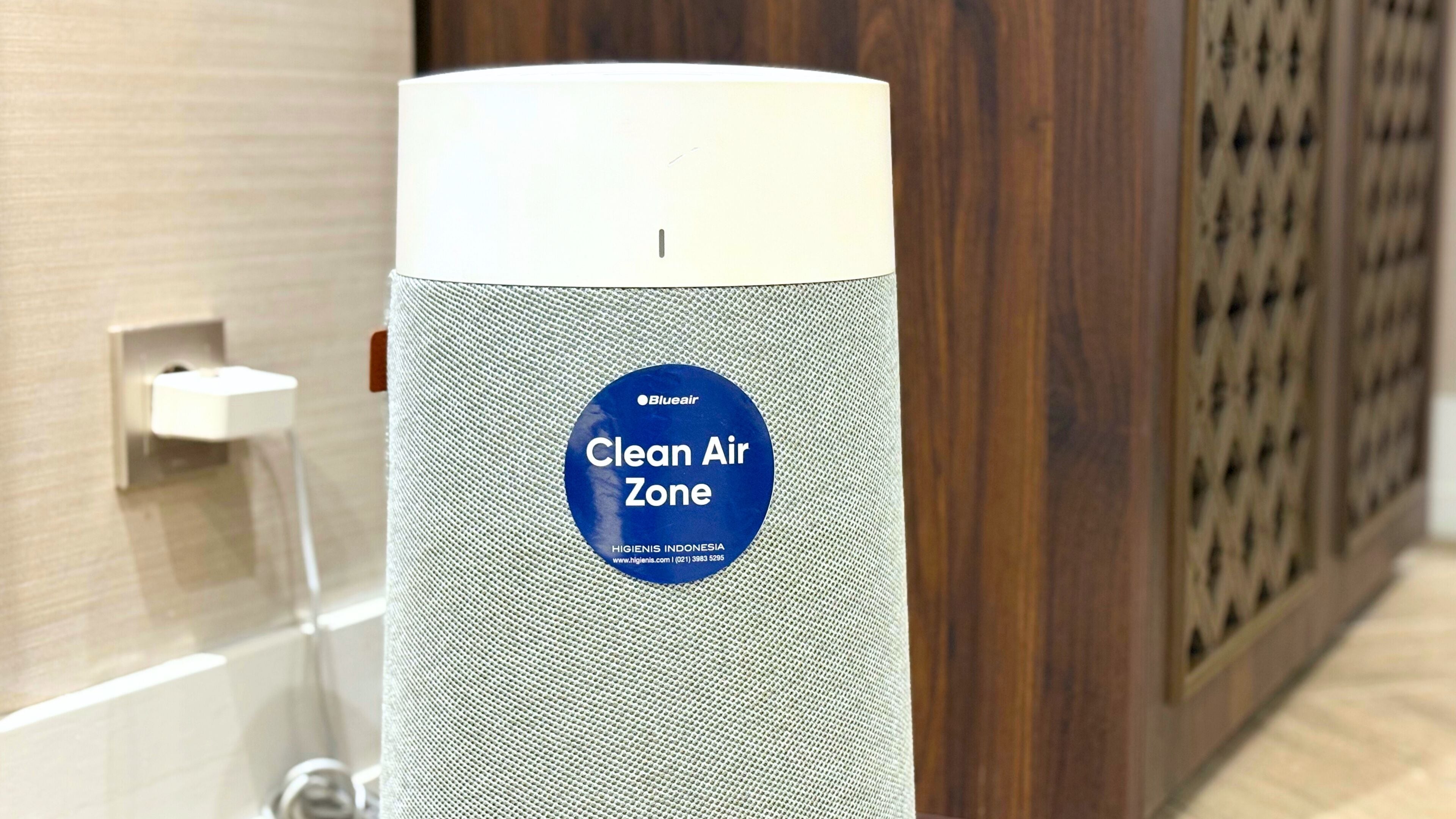 Um purificador de ar branco com um adesivo azul rotulado como 