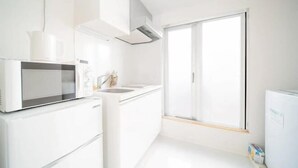 Cozinha moderna com armários brancos, micro-ondas e pia.