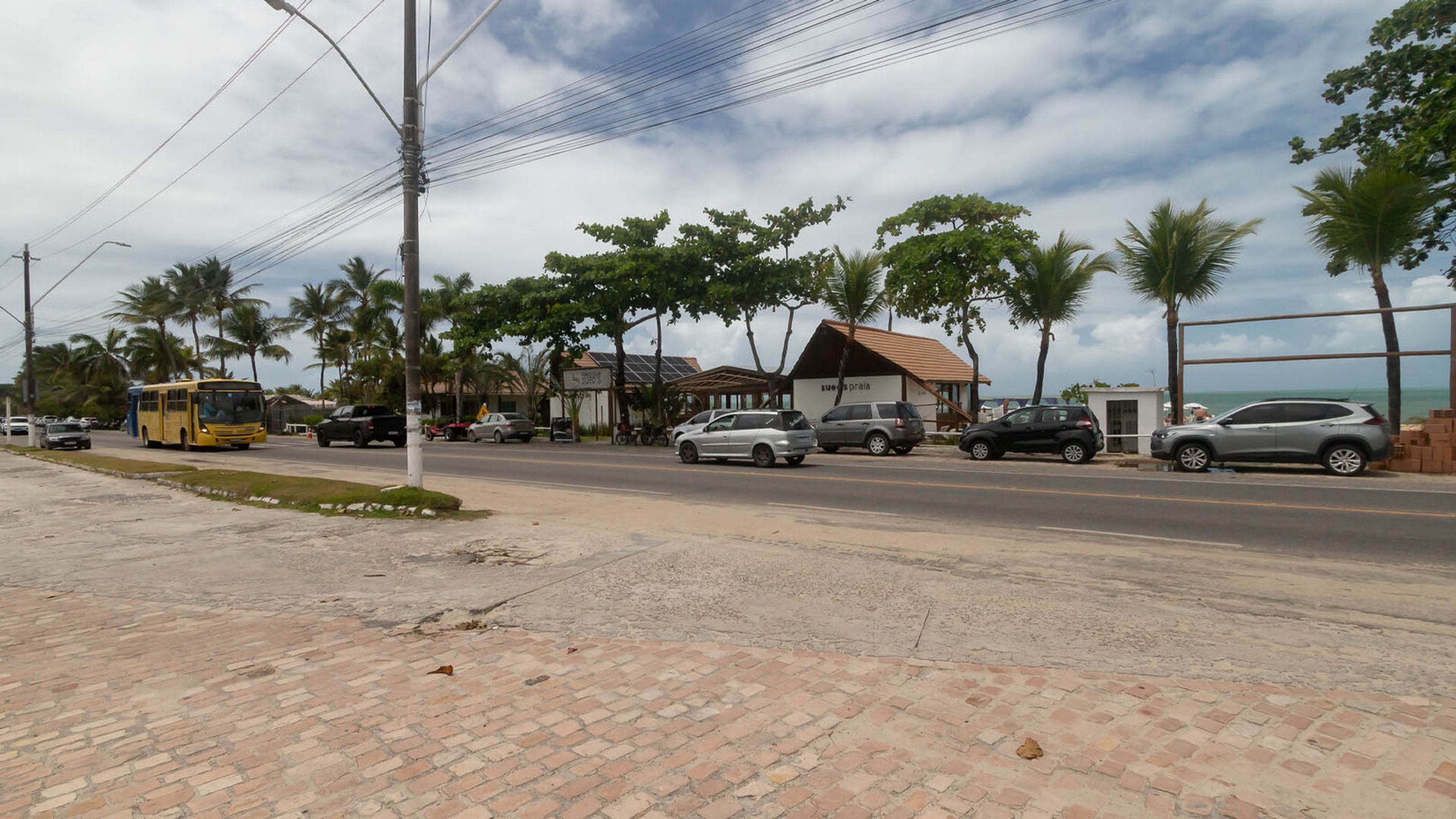 Ruas com ônibus, carros e um edifício com telhado de azulejos.