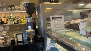 Vitrine de pastelaria com doces e uma máquina de café.