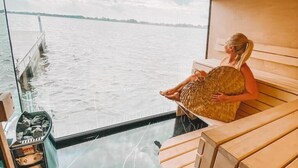 Uma sauna com vista para a água e um cais.