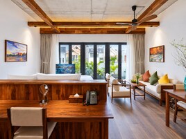 Uma sala de estar moderna com teto de madeira, um sofá, uma mesa de jantar e vista para o exterior.
