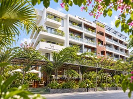 Um hotel moderno com várias varandas, mobiliário para áreas externas e vegetação exuberante.