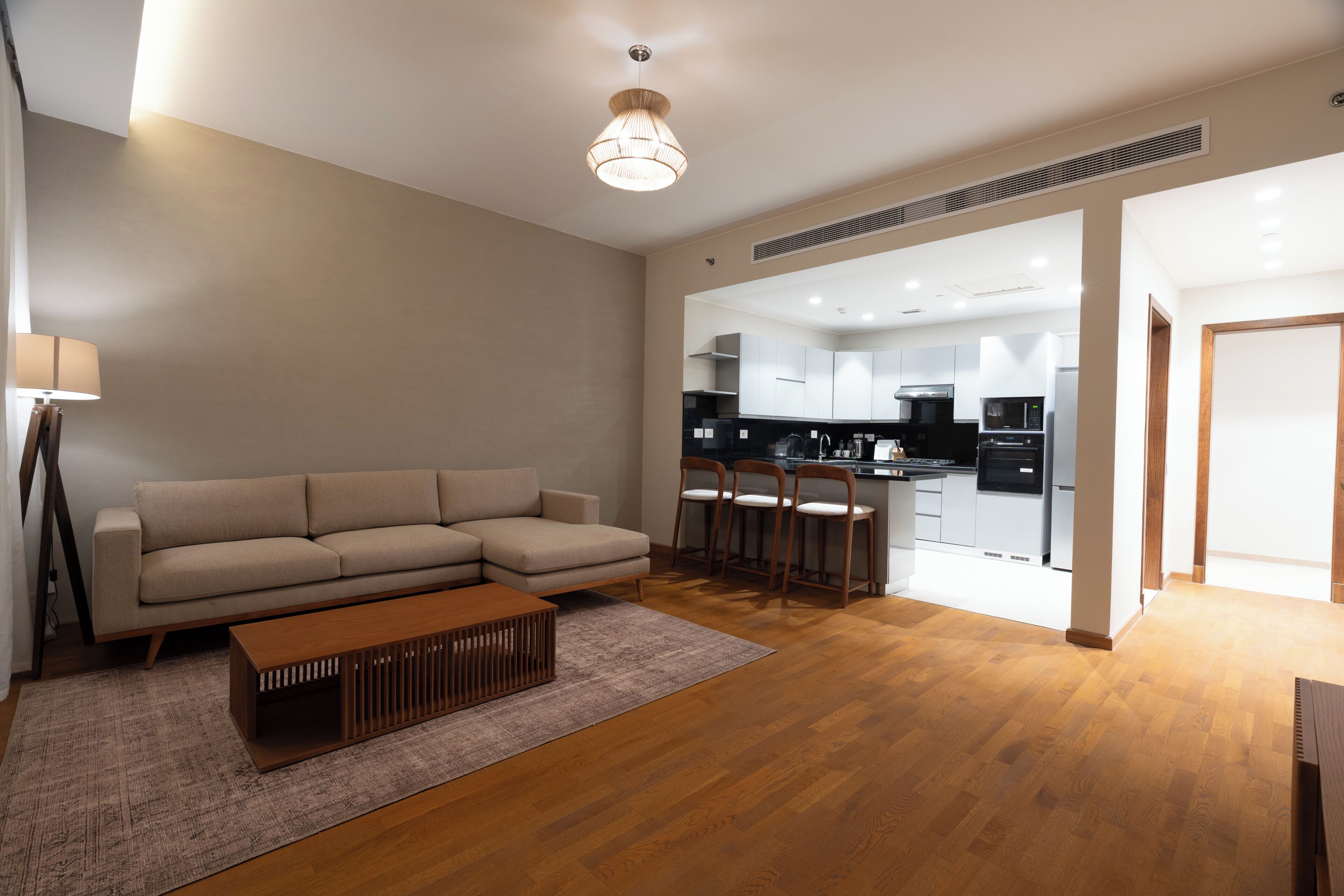 Uma sala de estar moderna com sofá, mesa de centro e um espaço de jantar com cadeiras.