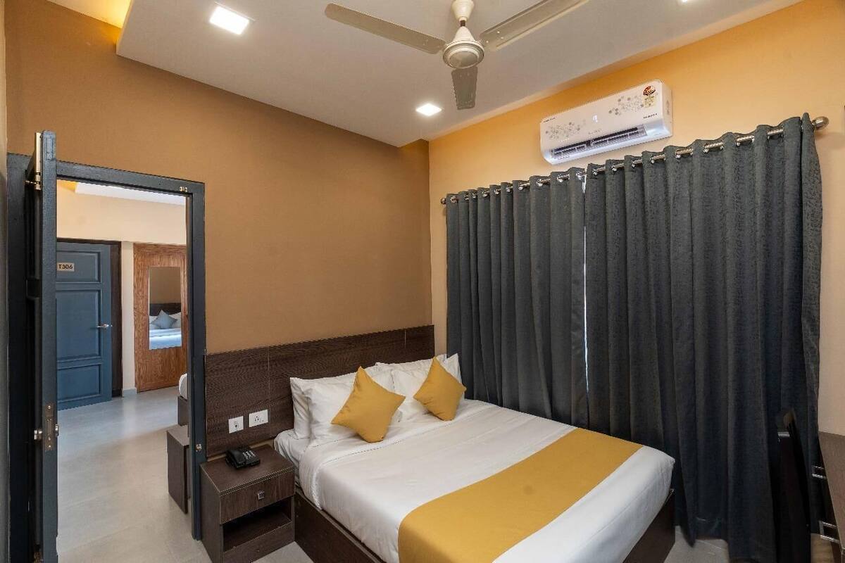 Quarto de hotel com cama, mesa de cabeceira e ar condicionado.