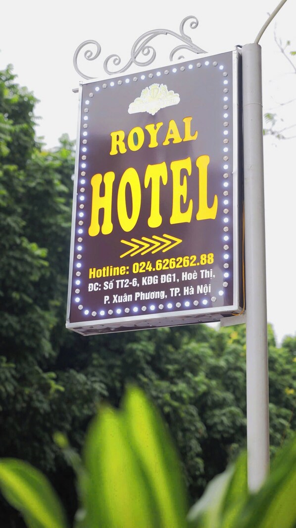 Placa do Hotel Royal com informações de contato e detalhes do endereço.