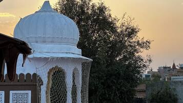 Um edifício branco com cúpula e janelas em arco, cercado por árvores e outros edifícios.