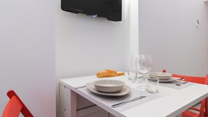 Mesa posta com pratos, copos, um pão e talheres.