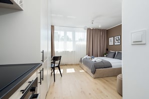 Um quarto moderno com uma cama, uma escrivaninha e uma cadeira.