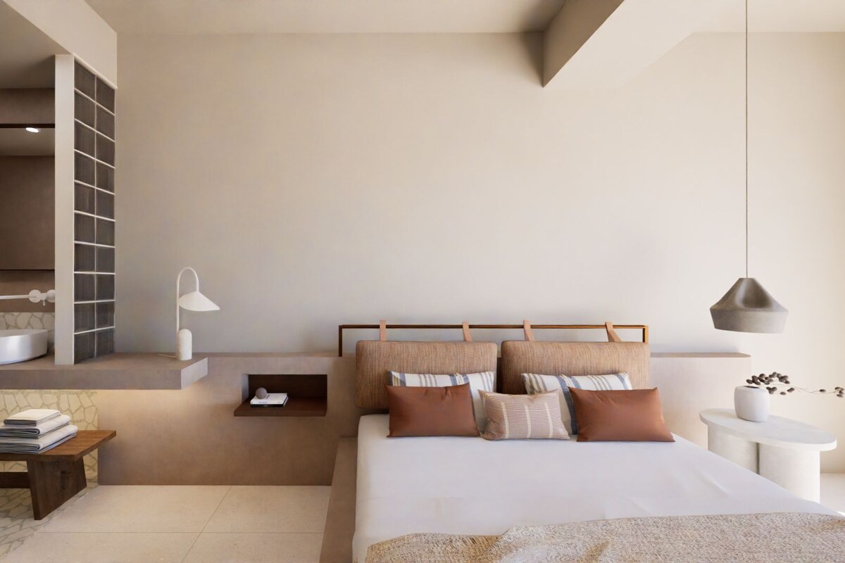 Quarto moderno com uma cama grande, mesas de cabeceira, um criado-mudo, uma estante embutida com espelho e uma luminária pendente.