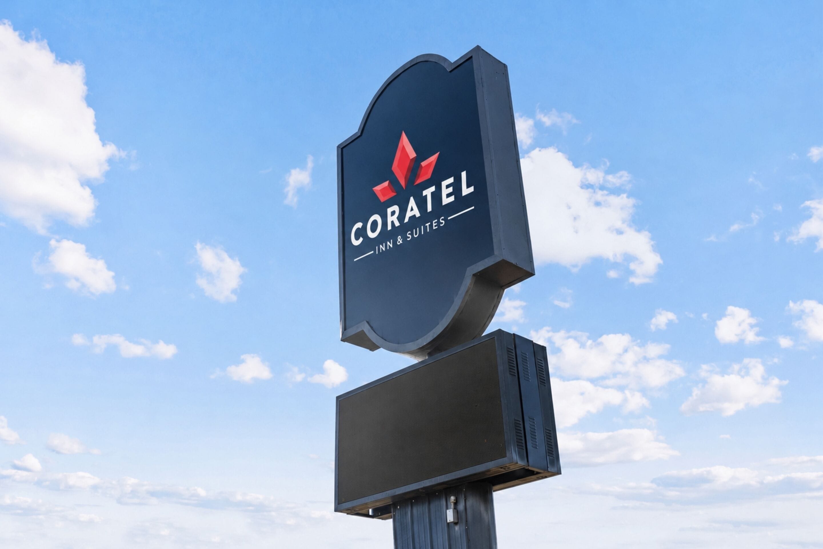 Placa de hotel com o nome 'CORATEL' e a inscrição 'INN & SUITES', indicando o tipo de acomodação.