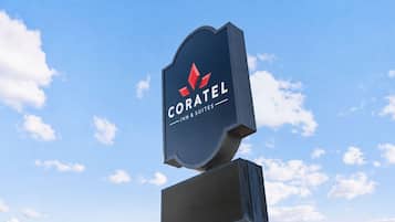 Placa de hotel com o nome 'CORATEL' e a inscrição 'INN & SUITES', indicando o tipo de acomodação.