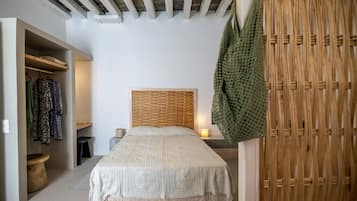 Quarto com cama, mesa de cabeceira e guarda-roupa.