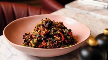 Uma tigela com legumes variados sobre uma superfície de mármore.