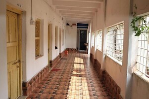 Um corredor com chão estampado, portas e janelas com grades.