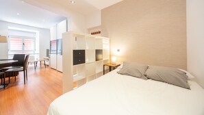 Quarto de hotel moderno com uma cama, uma escrivaninha e uma cadeira.