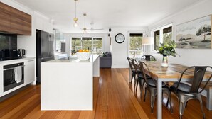 Uma cozinha moderna com armários brancos, eletrodomésticos de aço inoxidável e uma ilha central.