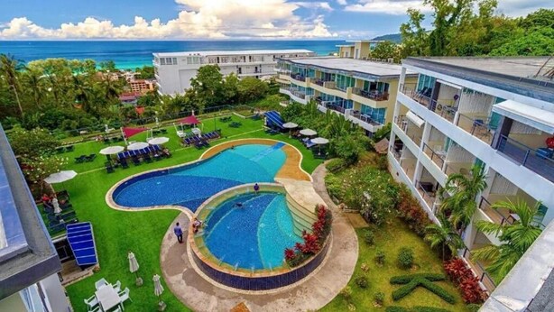 Hotel com piscina, várias varandas e vista para o oceano.