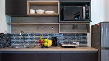 Uma cozinha moderna com uma pia de aço inoxidável, um micro-ondas e uma geladeira.