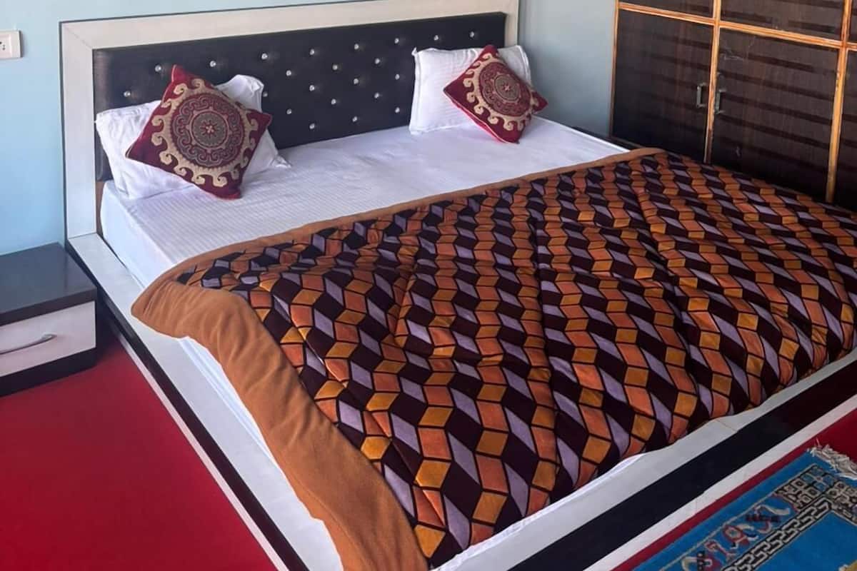 Quarto com cama, guarda-roupa e tapete vermelho.
