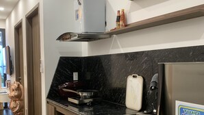 Uma cozinha moderna com bancada de mármore preto, eletrodomésticos de aço inoxidável e armários de madeira.