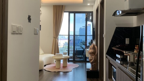Um apartamento moderno com cozinha, sala de estar e uma janela grande com vista para a cidade.