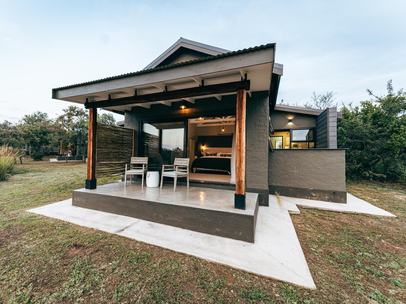 Uma casa moderna com varanda coberta, área de refeições e cozinha à vista.