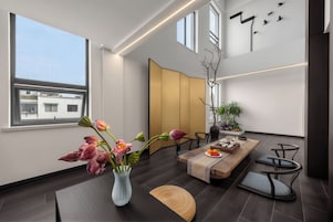 A modern interior with a dining area, a large window, and a view of the sky.