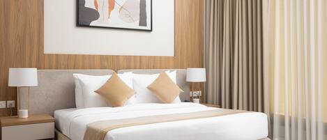 Quarto de hotel moderno com cama, mesas de cabeceira, abajur, obra de arte abstrata emoldurada e janela com cortinas.