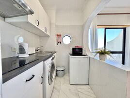 Um micro-ondas, uma cafeteira/bule, utensílios de cozinha