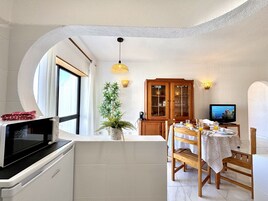 Um micro-ondas, uma cafeteira/bule, utensílios de cozinha 