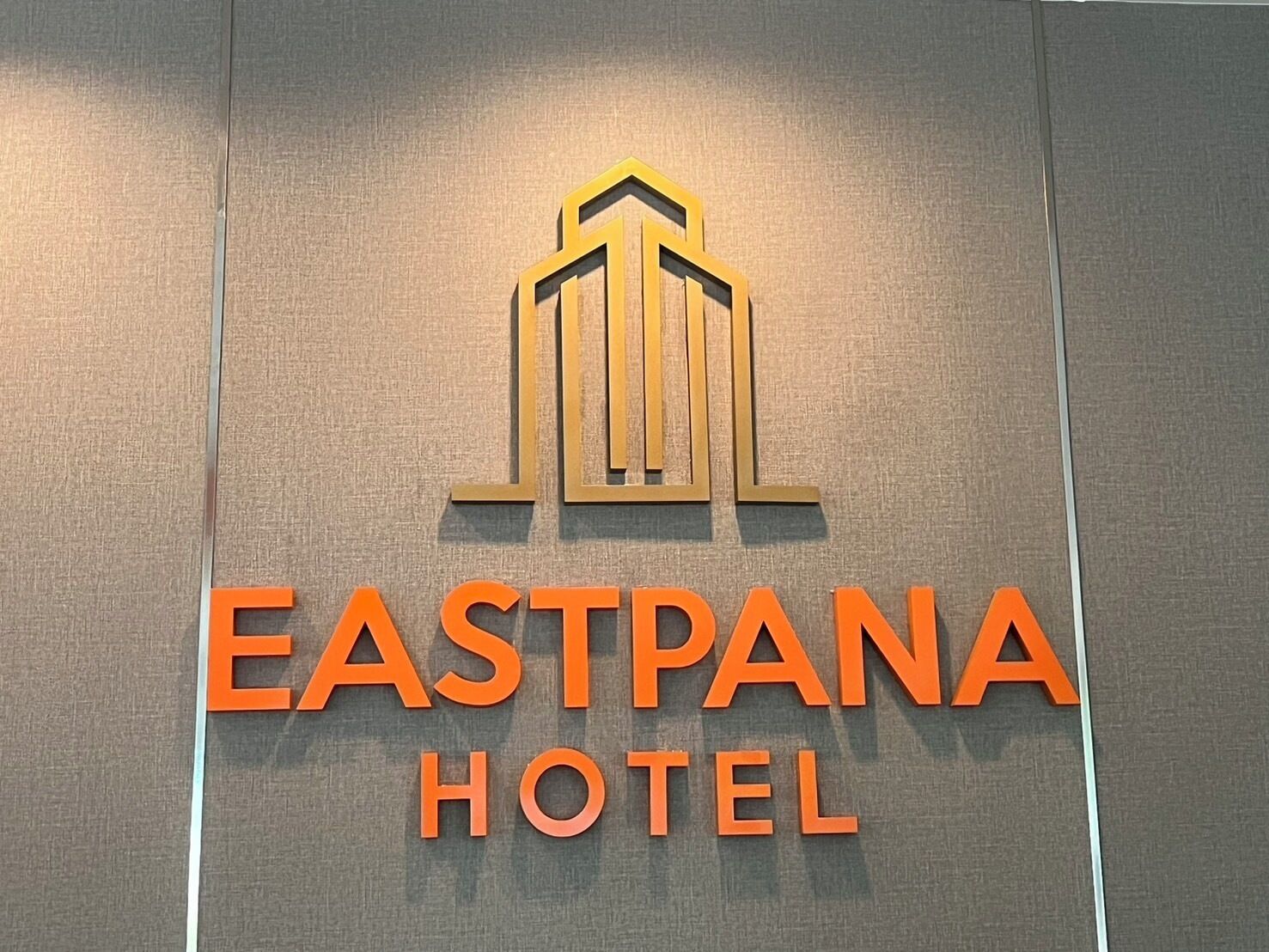 Um letreiro do Hotel Eastpana, com o logotipo do edifício em estilo estilizado e o nome do hotel em letras negrito.