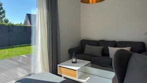 Uma sala de estar moderna com um sofá, uma mesinha e um candeeiro suspenso.