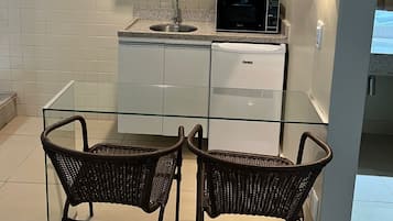Suíte superior, 1 quarto, cozinha americana, vista para a piscina | Cozinha privada | Frigobar, micro-ondas, cadeirão de bebê, mesas de jantar