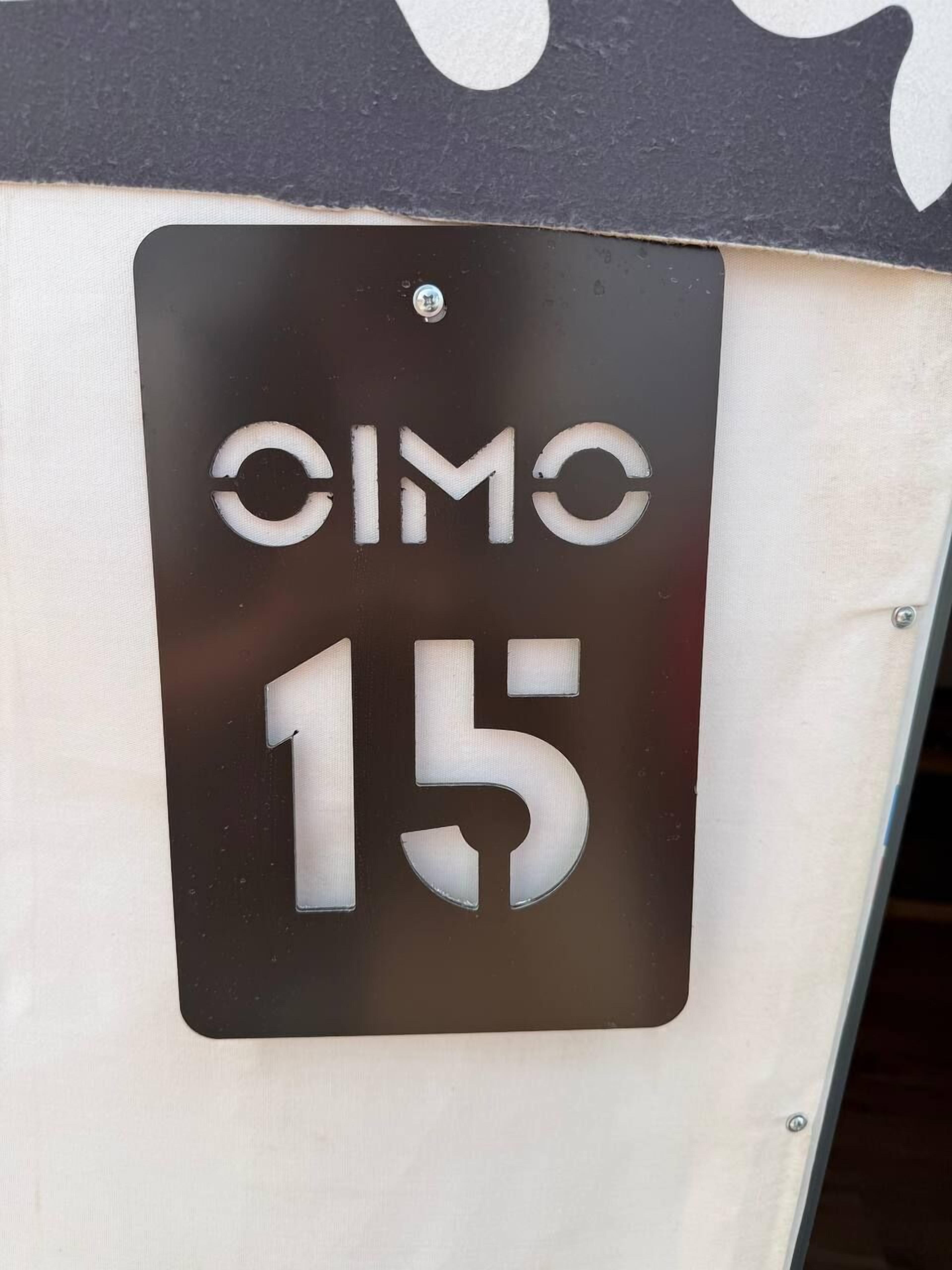 Um sinal na parede com o texto 'CIMO 15'.