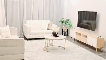 Apartamento Deluxe, Vista para a cidade | Sala de estar | Smart TV de 32 polegadas com canais digitais