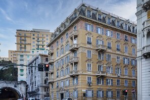 Um edifício de vários andares com detalhes arquitetônicos elaborados, incluindo varandas e molduras decorativas.